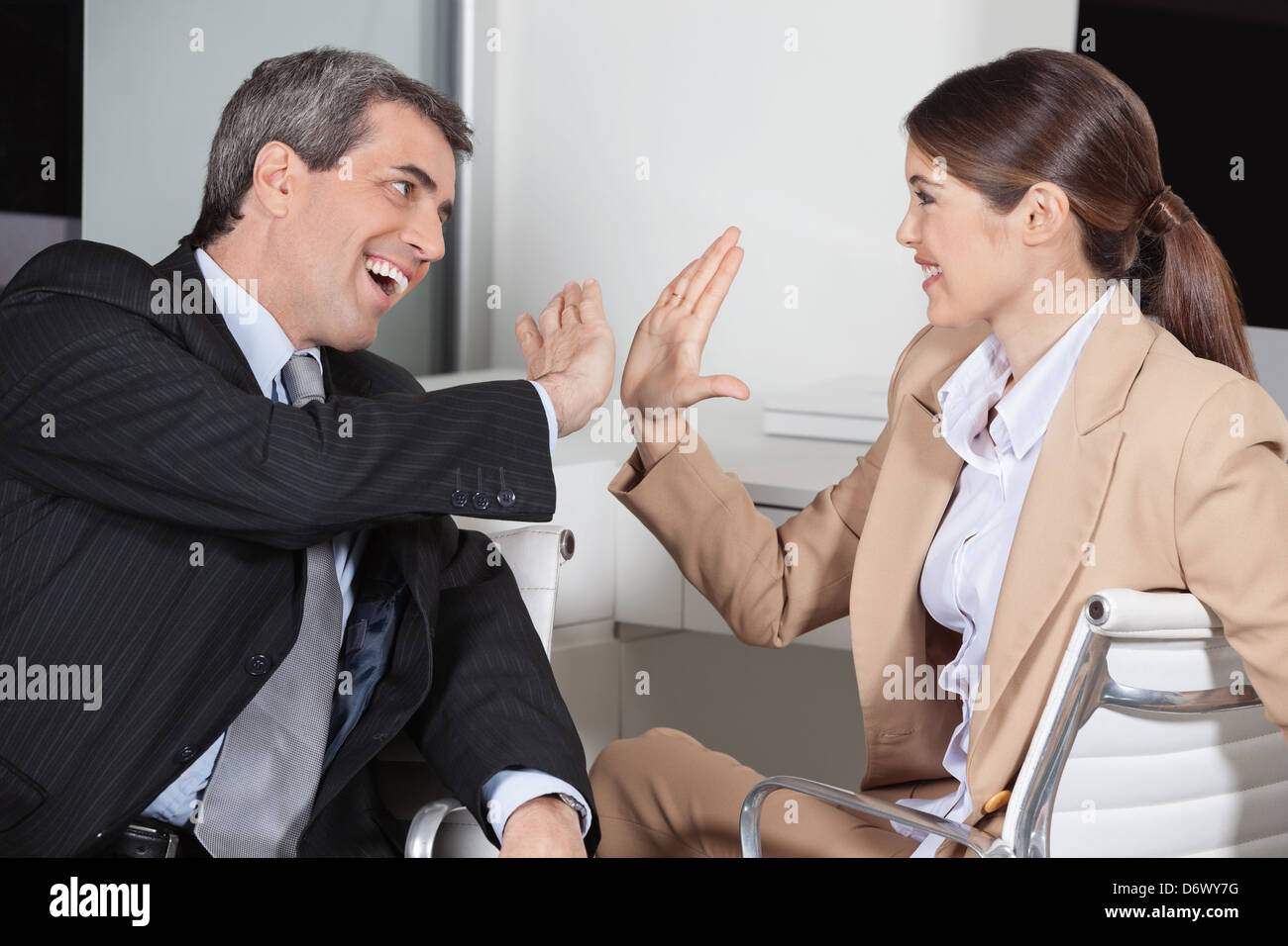 Manager and employee in the office giving high five to each other Stock ...