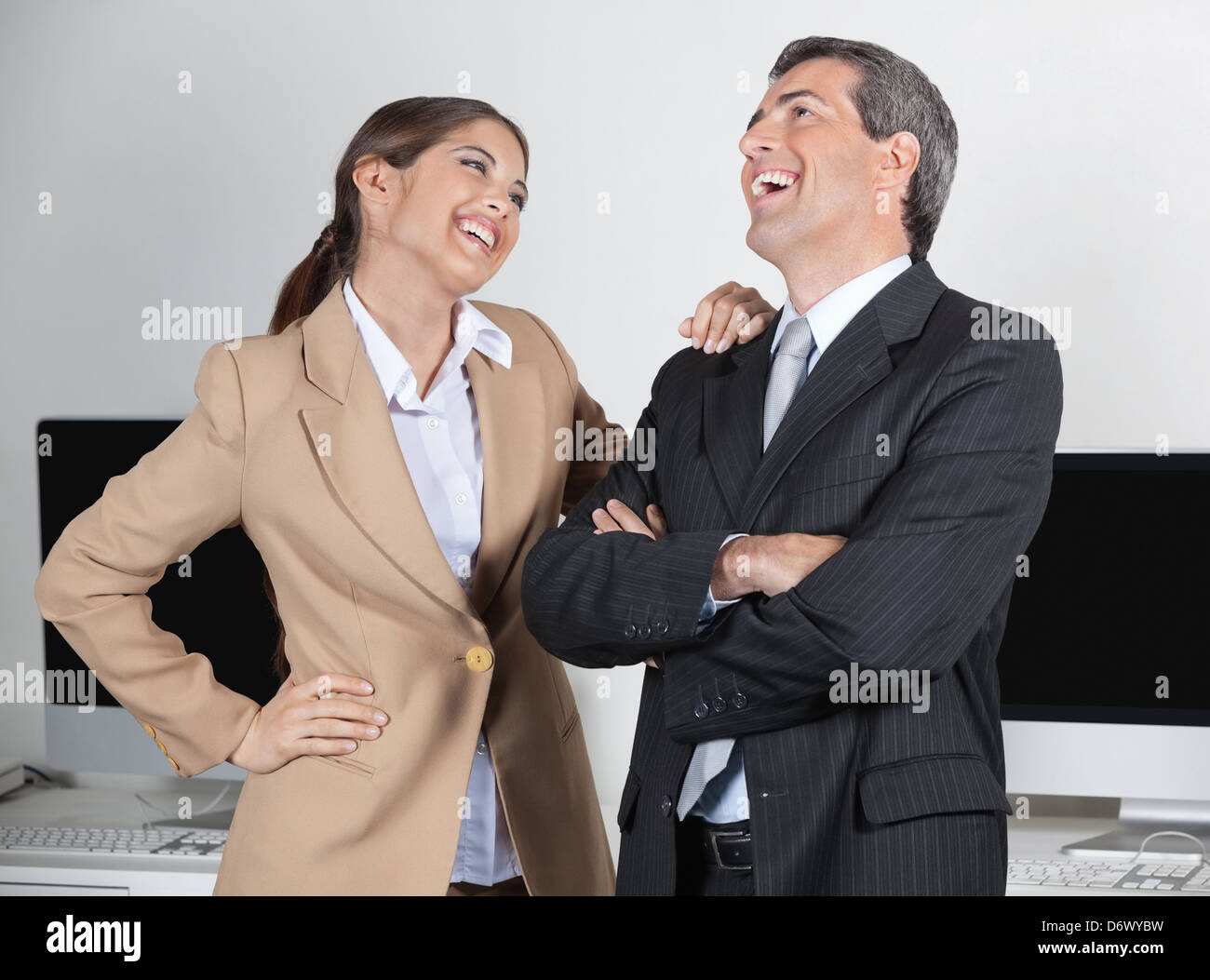 Happy manager and secretary laughing about a joke in the office Stock ...
