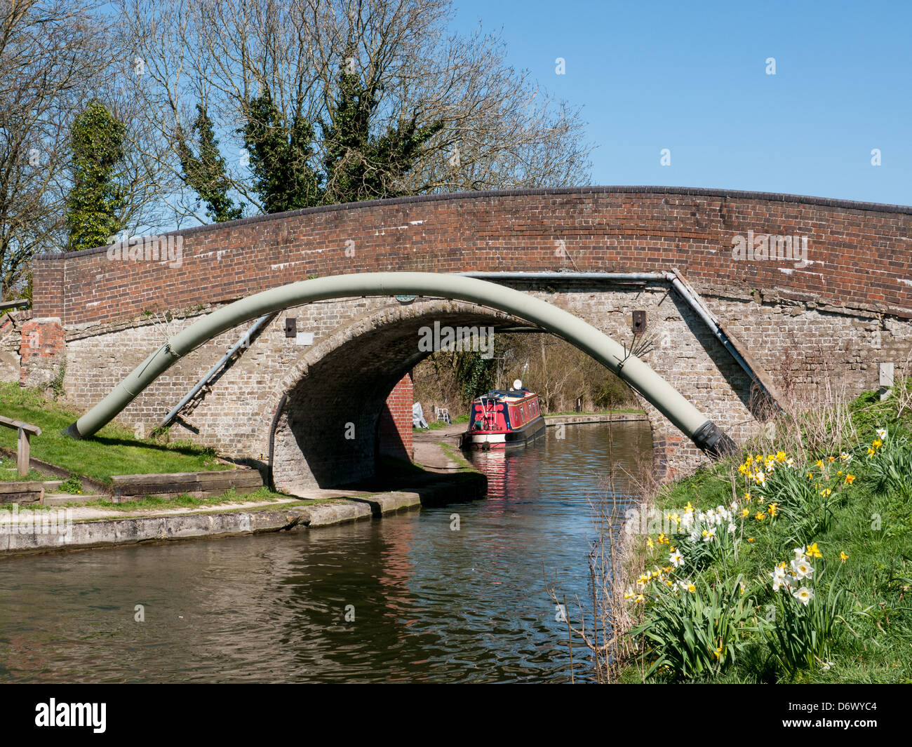 Narrow boat seen under a bridge over the Grand Union Canal at Marsworth ...