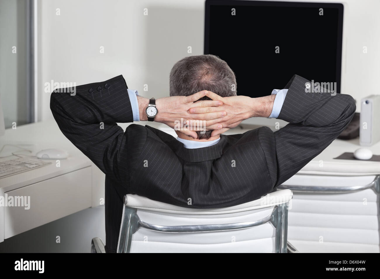 Relaxed manager at his desk leaning back in the office Stock Photo - Alamy