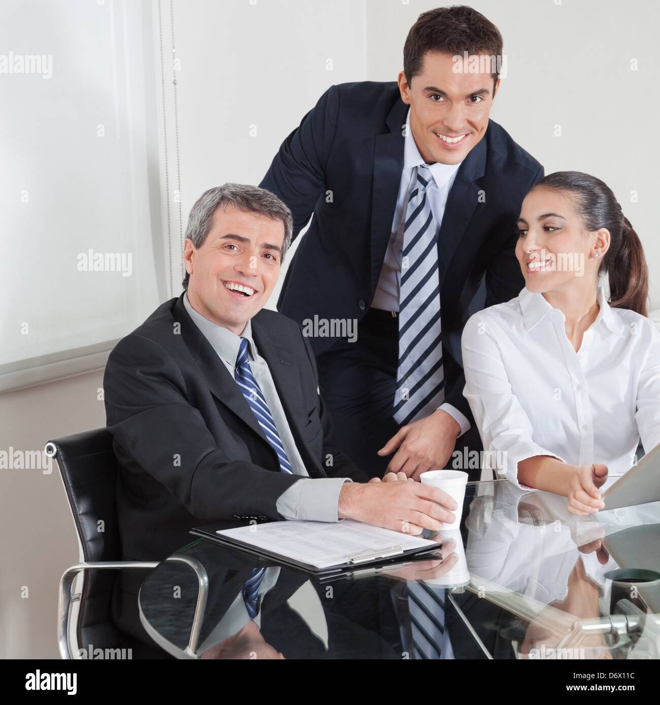Smiling business team sitting at a conference table for a meeting Stock ...