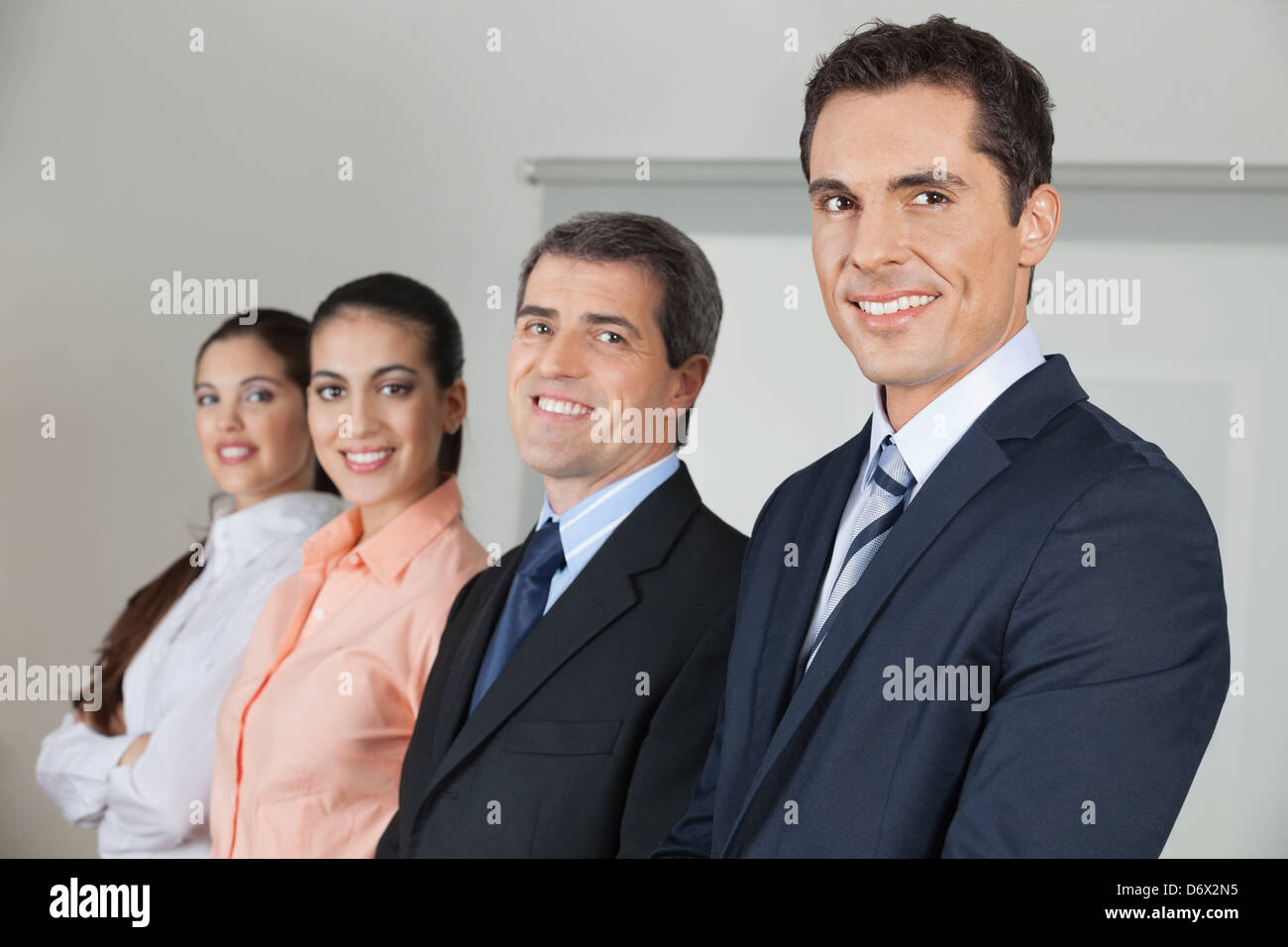 Row of four happy businesspeople in the office Stock Photo - Alamy
