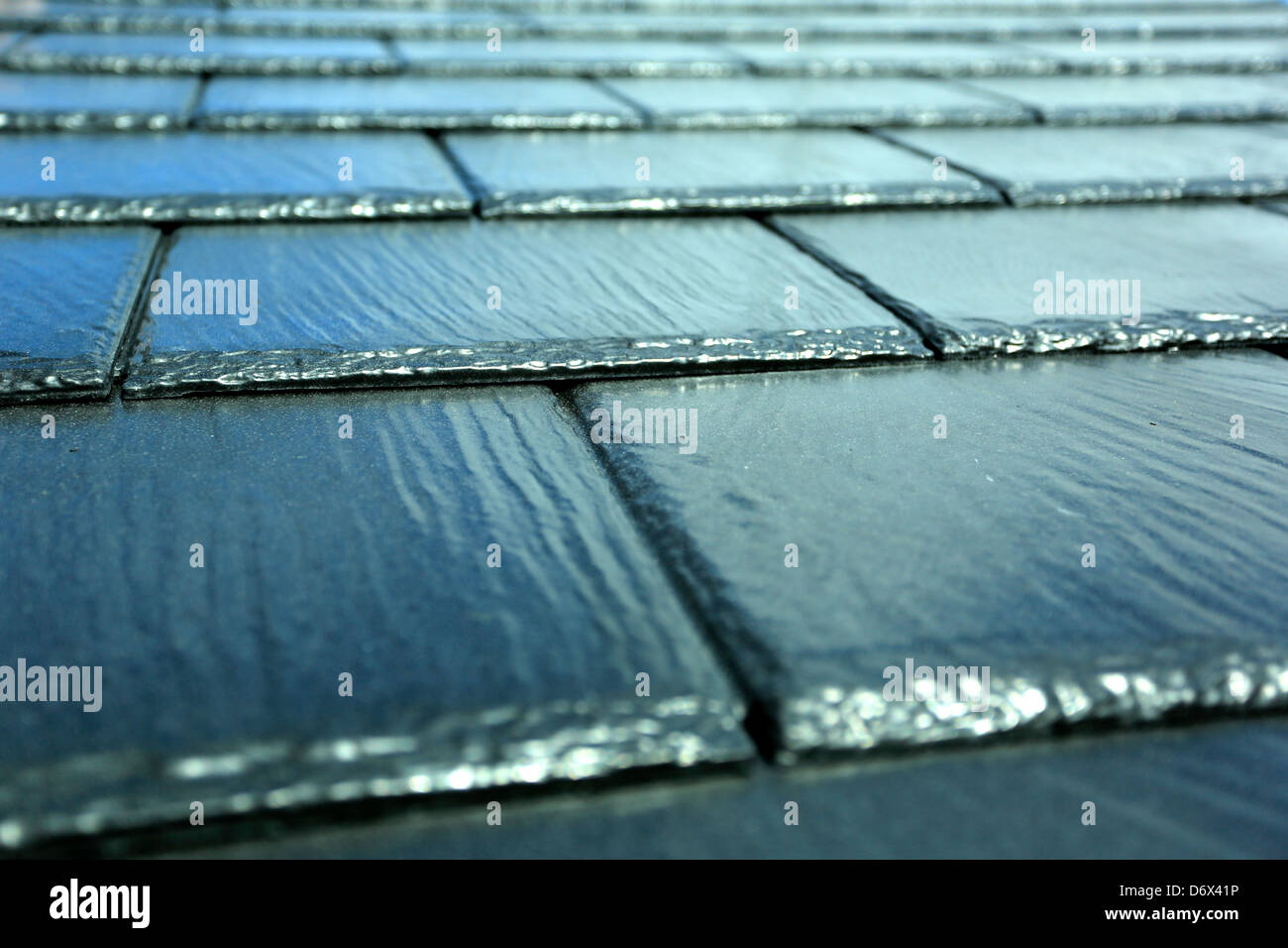 Slate tiles being fitted on new house roof by construction worker Stock ...