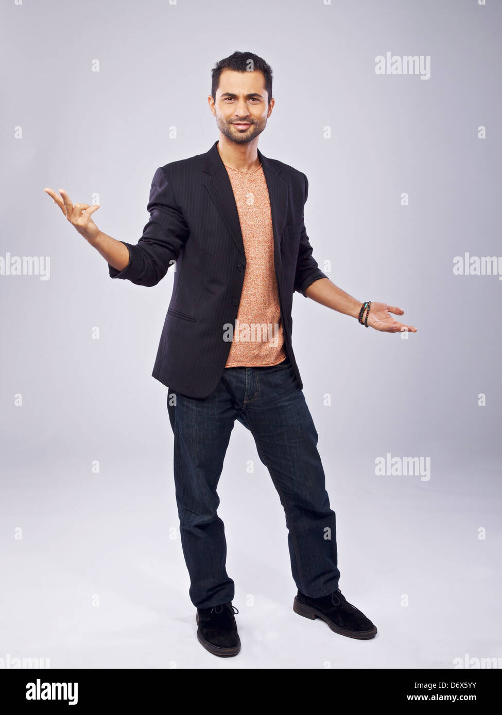 Confident man standing in a studio doing hand gesture Stock Photo - Alamy