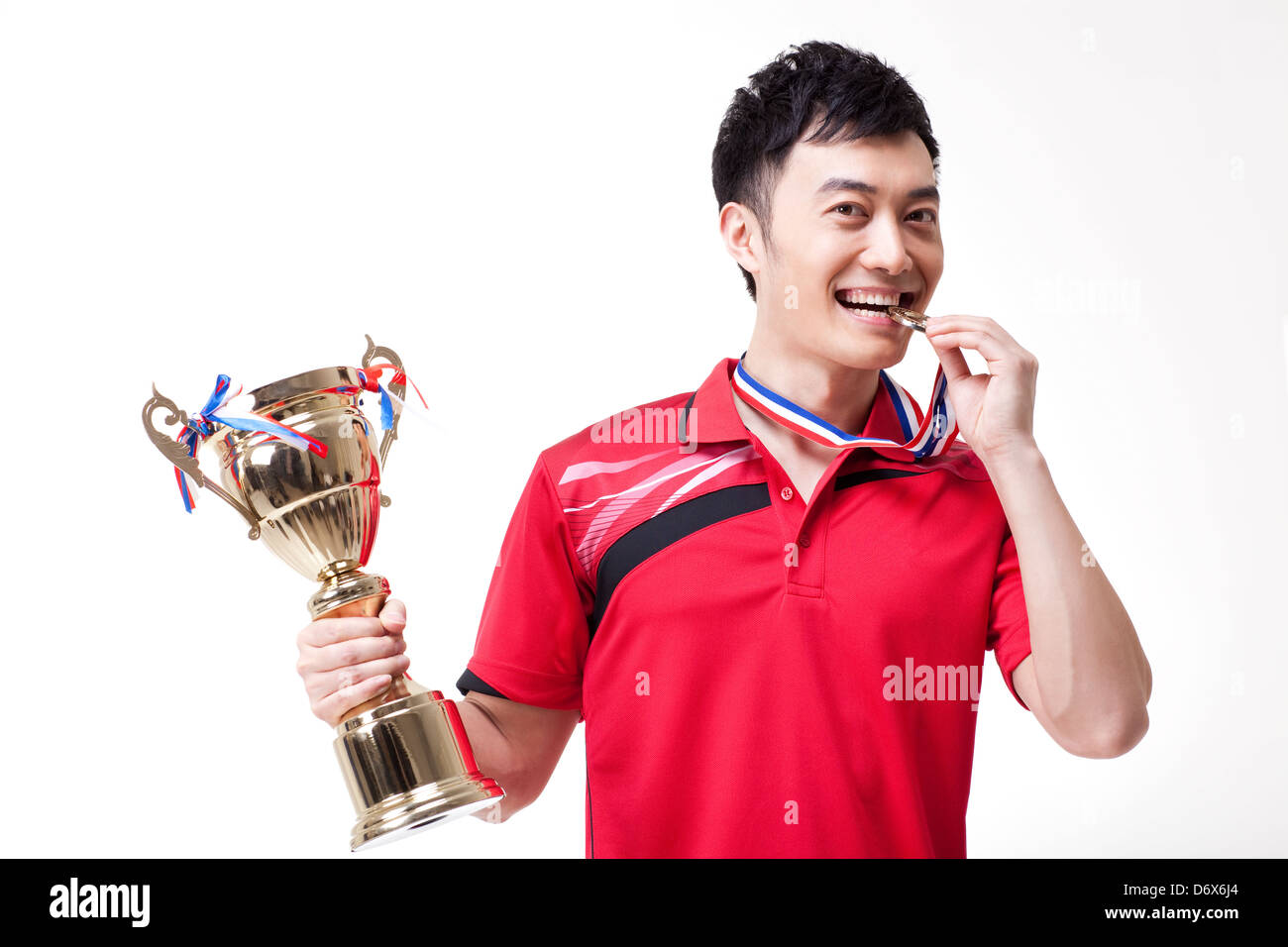 Male athlete celebrating victory with gold medal and trophy Stock Photo ...