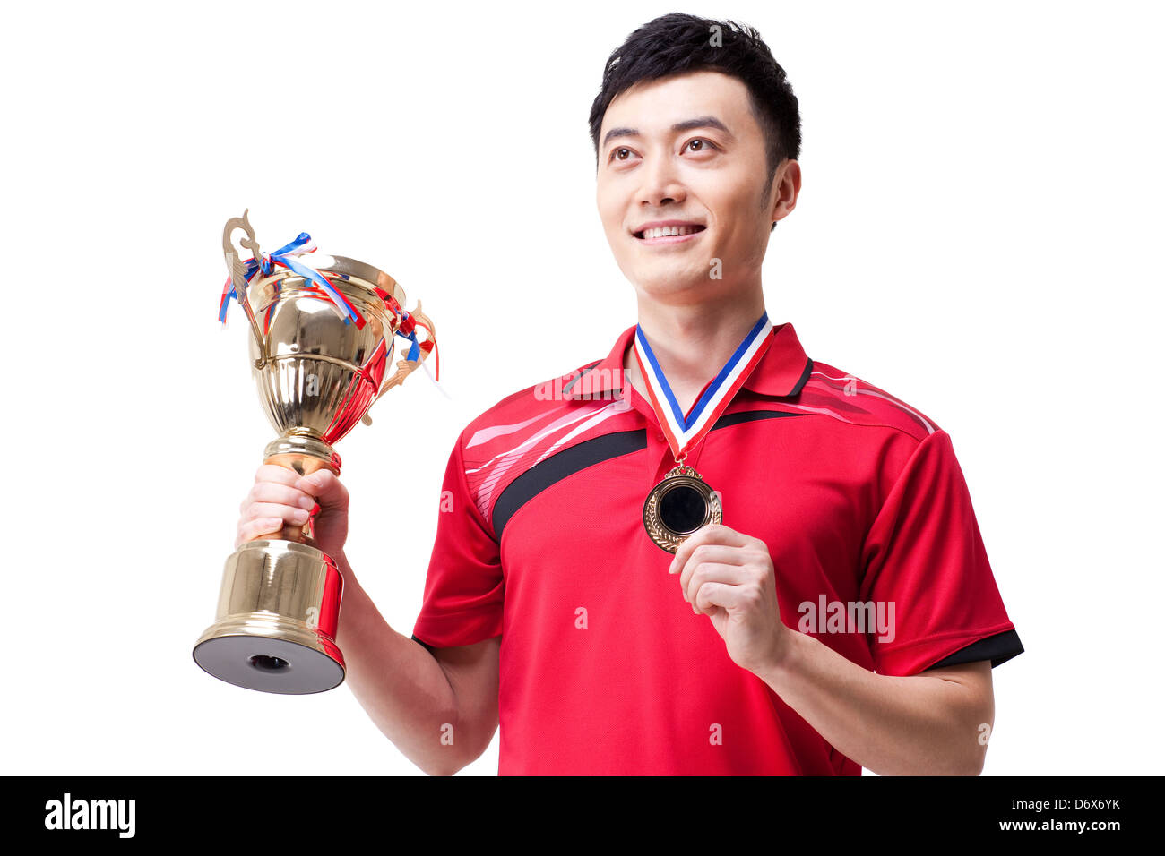 Male athlete celebrating victory with gold medal and trophy Stock Photo ...
