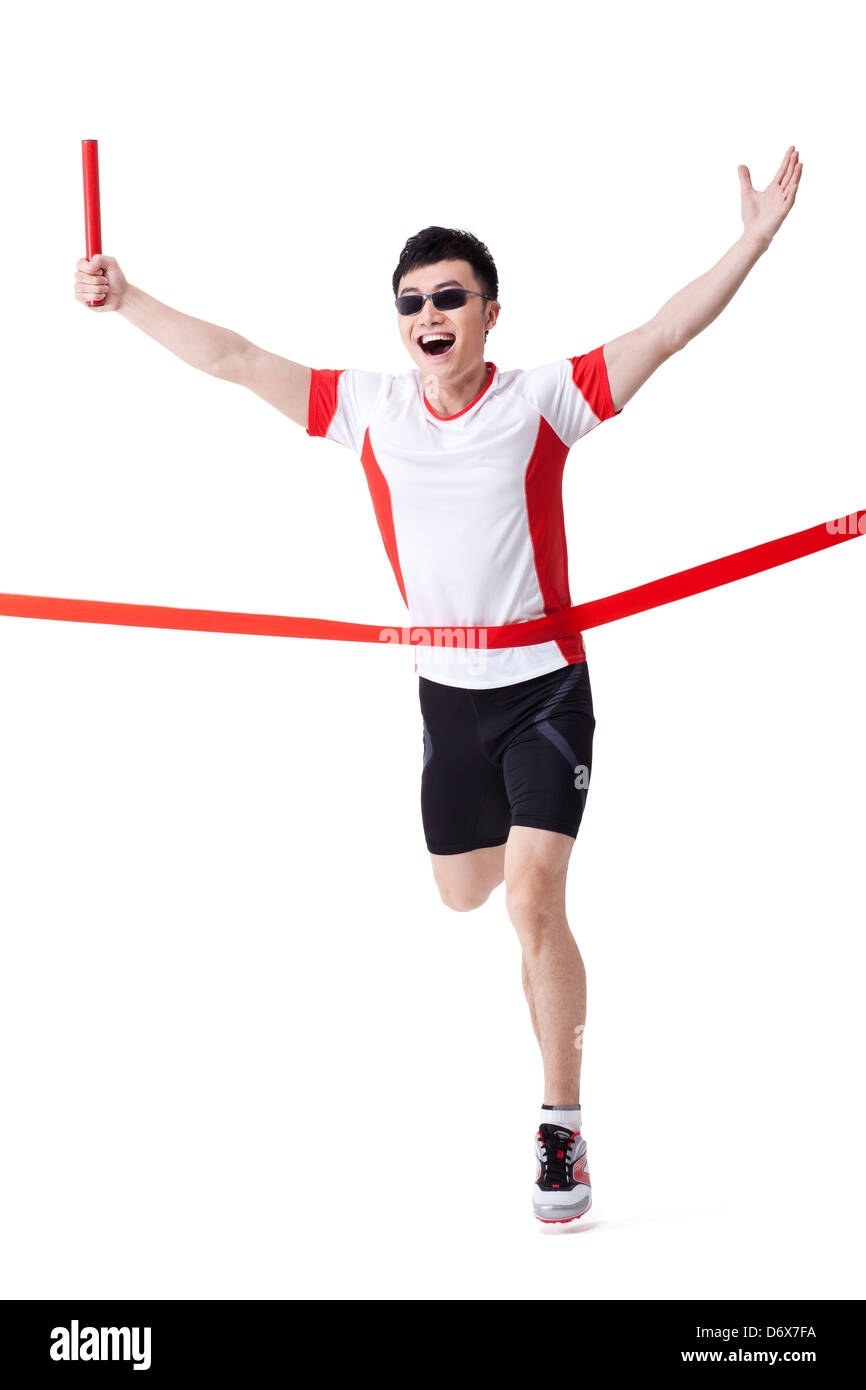 Male athlete with relay baton reaching the finish line Stock Photo - Alamy