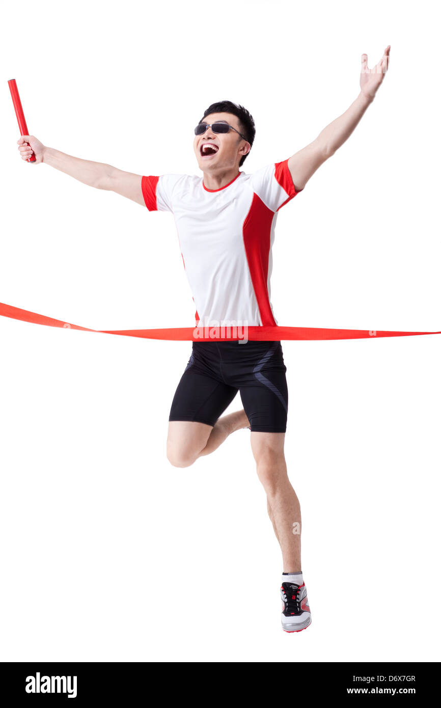 Male athlete with relay baton reaching the finish line Stock Photo - Alamy