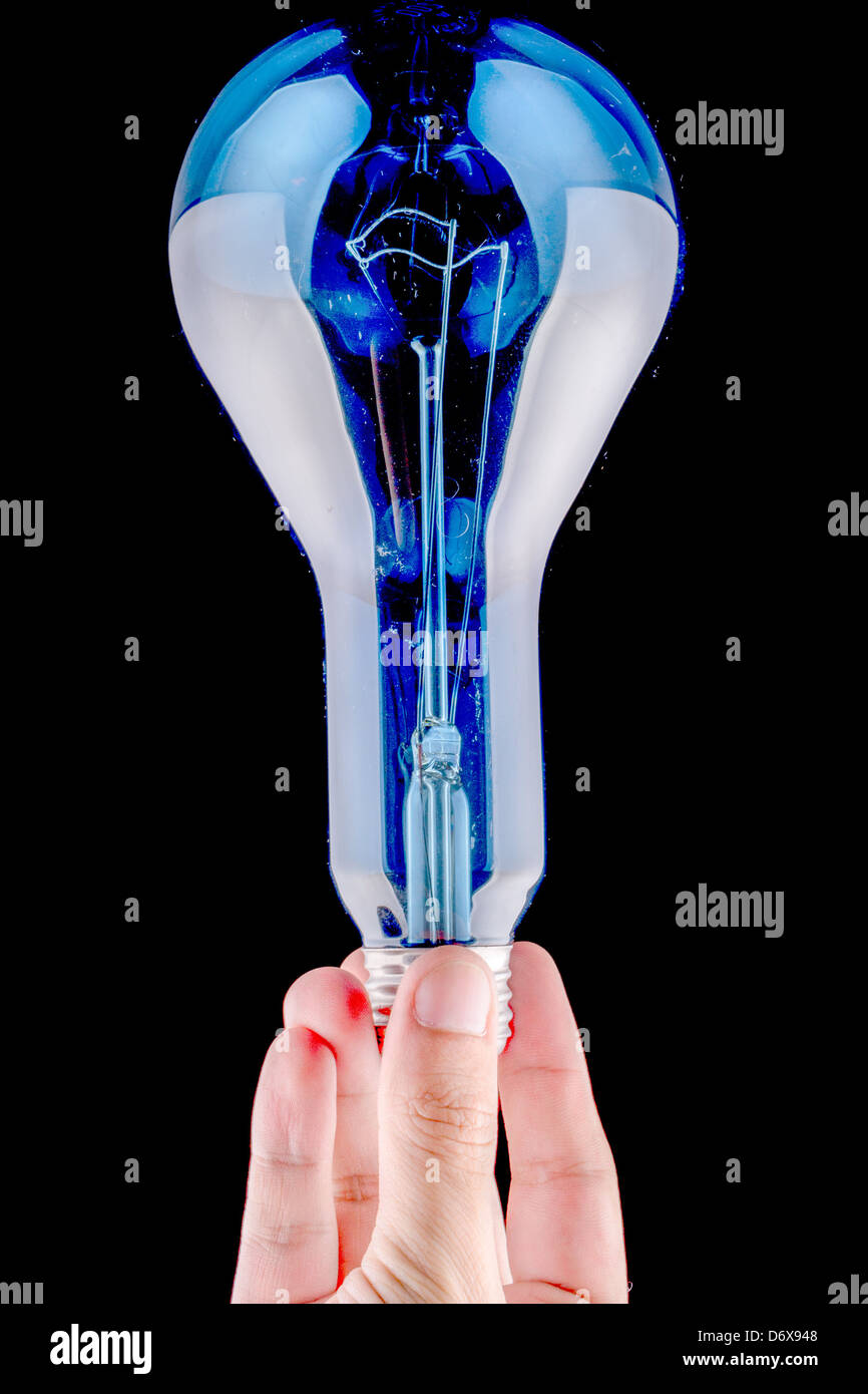 Hand holding light bulb isolated on black Stock Photo - Alamy