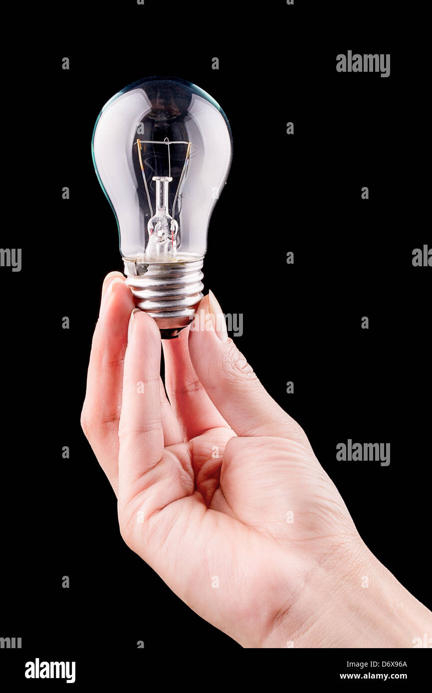 Hand holding light bulb isolated on black Stock Photo - Alamy