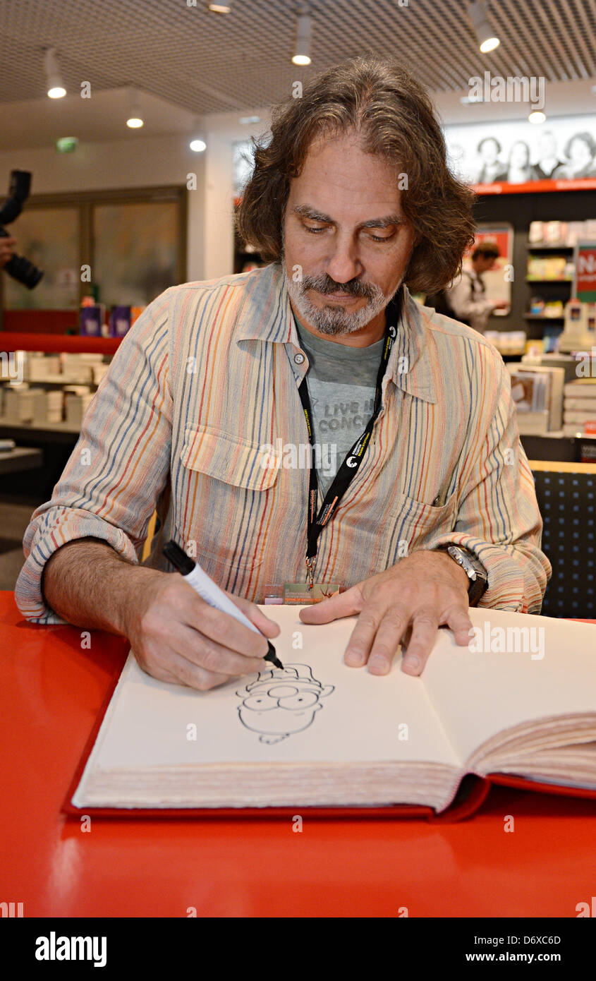 Director David Silverman drwas a Simpson figure during an autograph ...