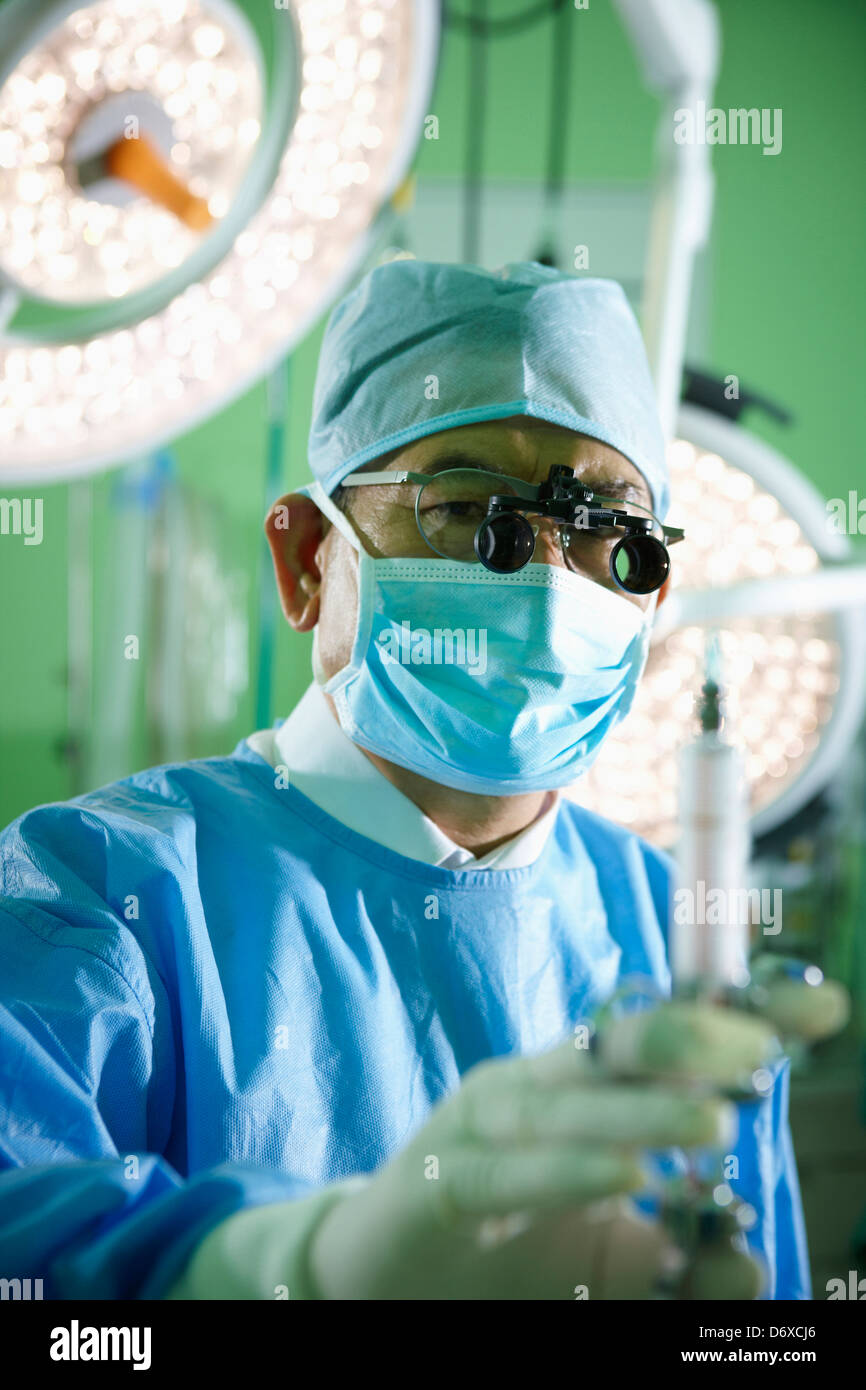 a surgeon wearing a medical loop glasses holding injection Stock Photo ...