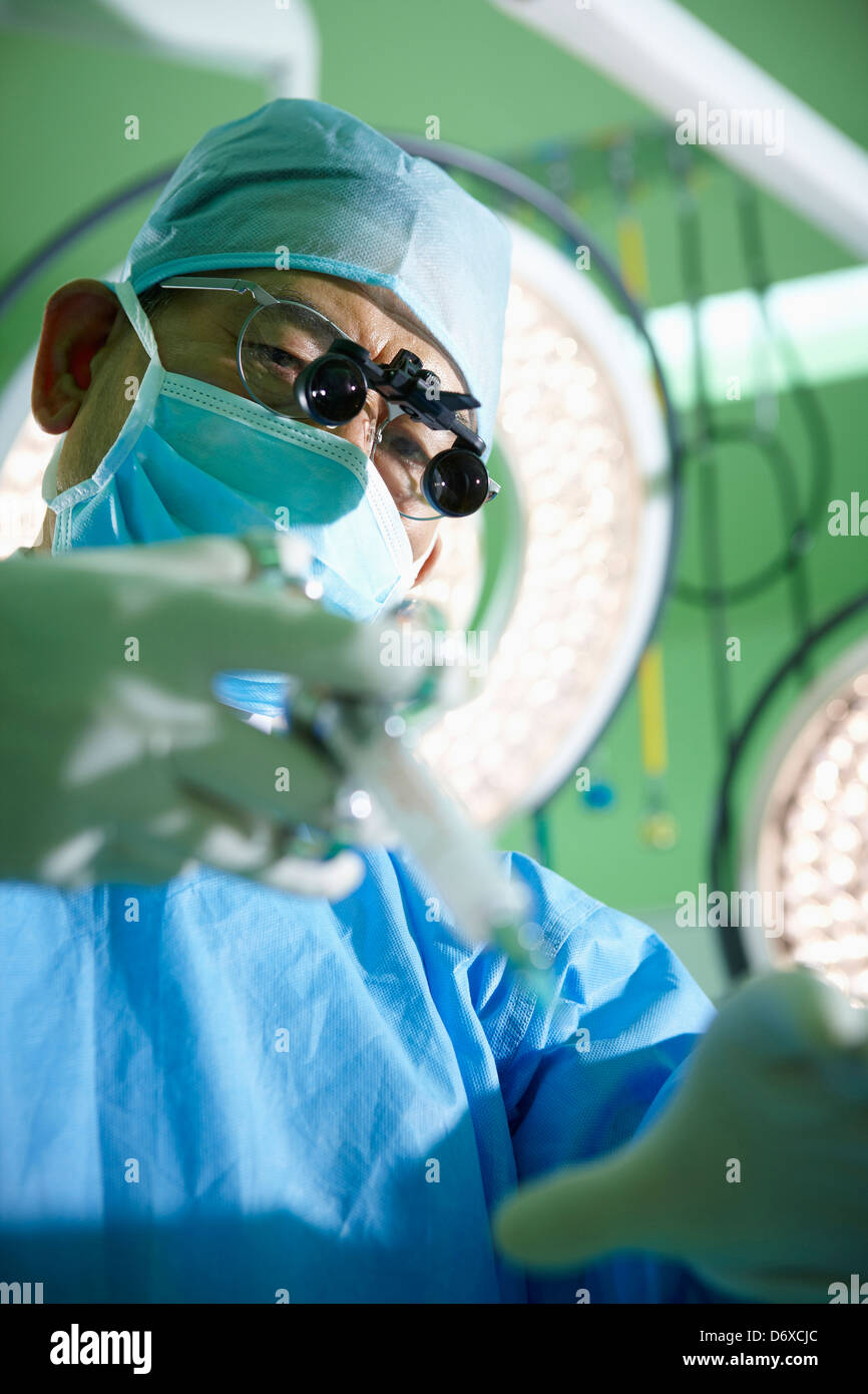 a surgeon wearing a medical loop glasses holding injection Stock Photo ...
