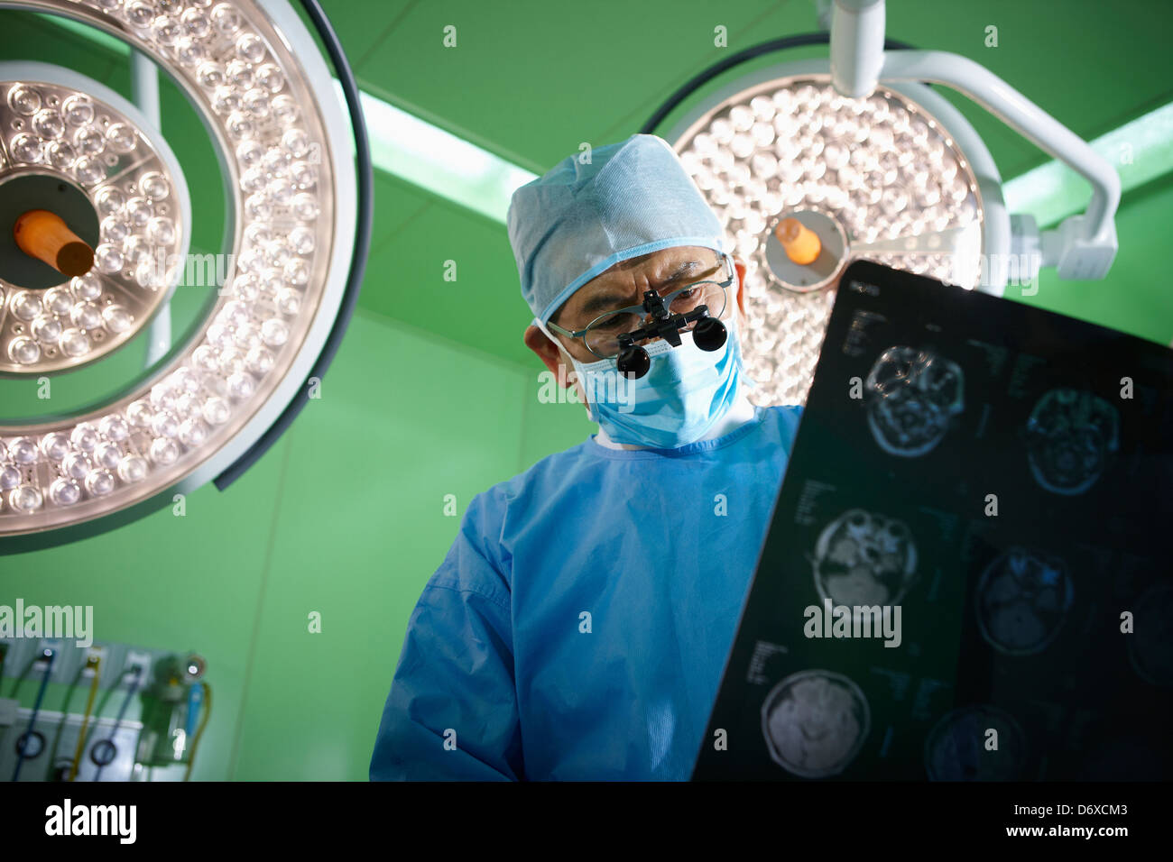 a surgeon wearing a medical loop glasses looking at x ray image Stock ...