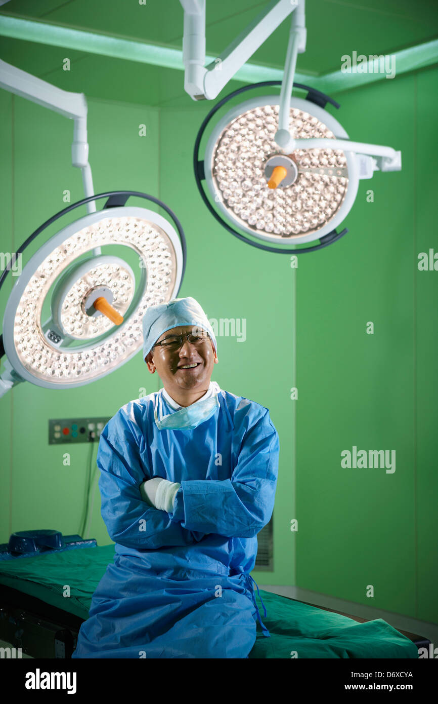 a surgeon sitting on a operation bed with arms crossed Stock Photo - Alamy