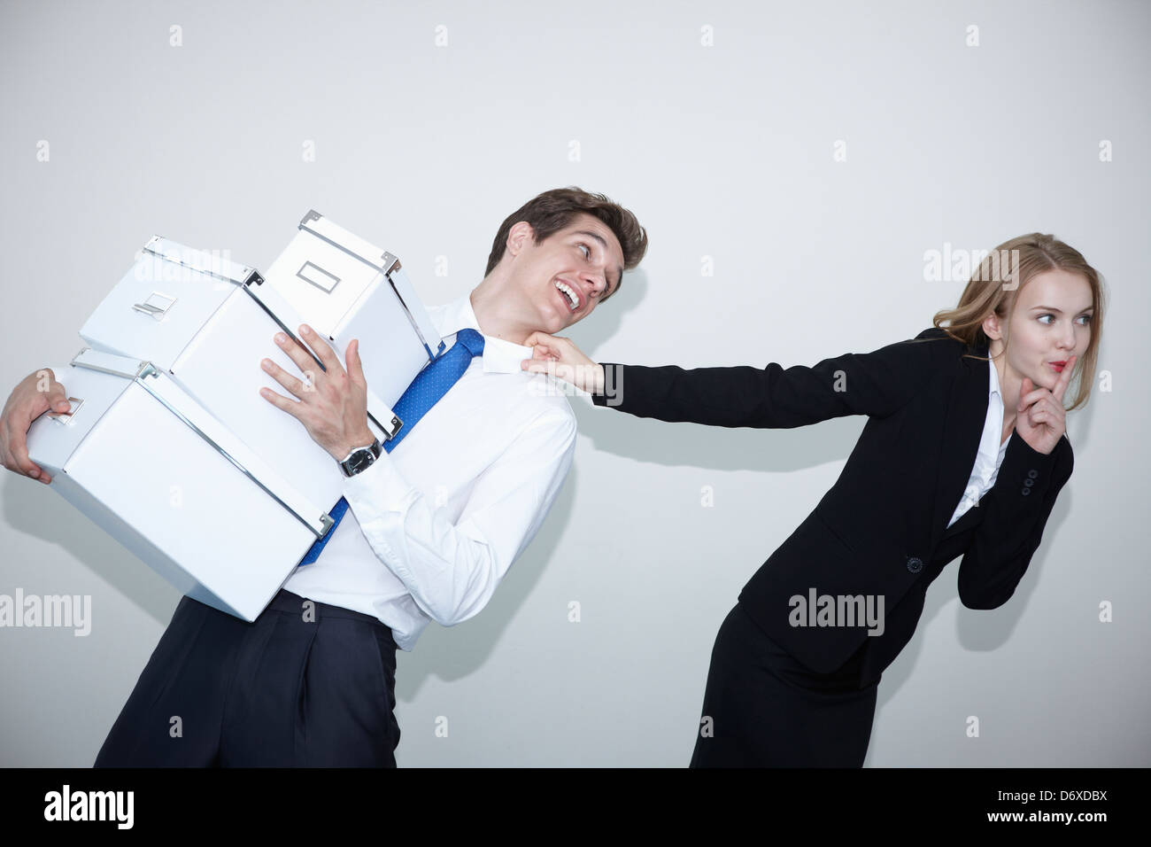 a businesswoman pulling a businessman holding a pile of boxes Stock ...