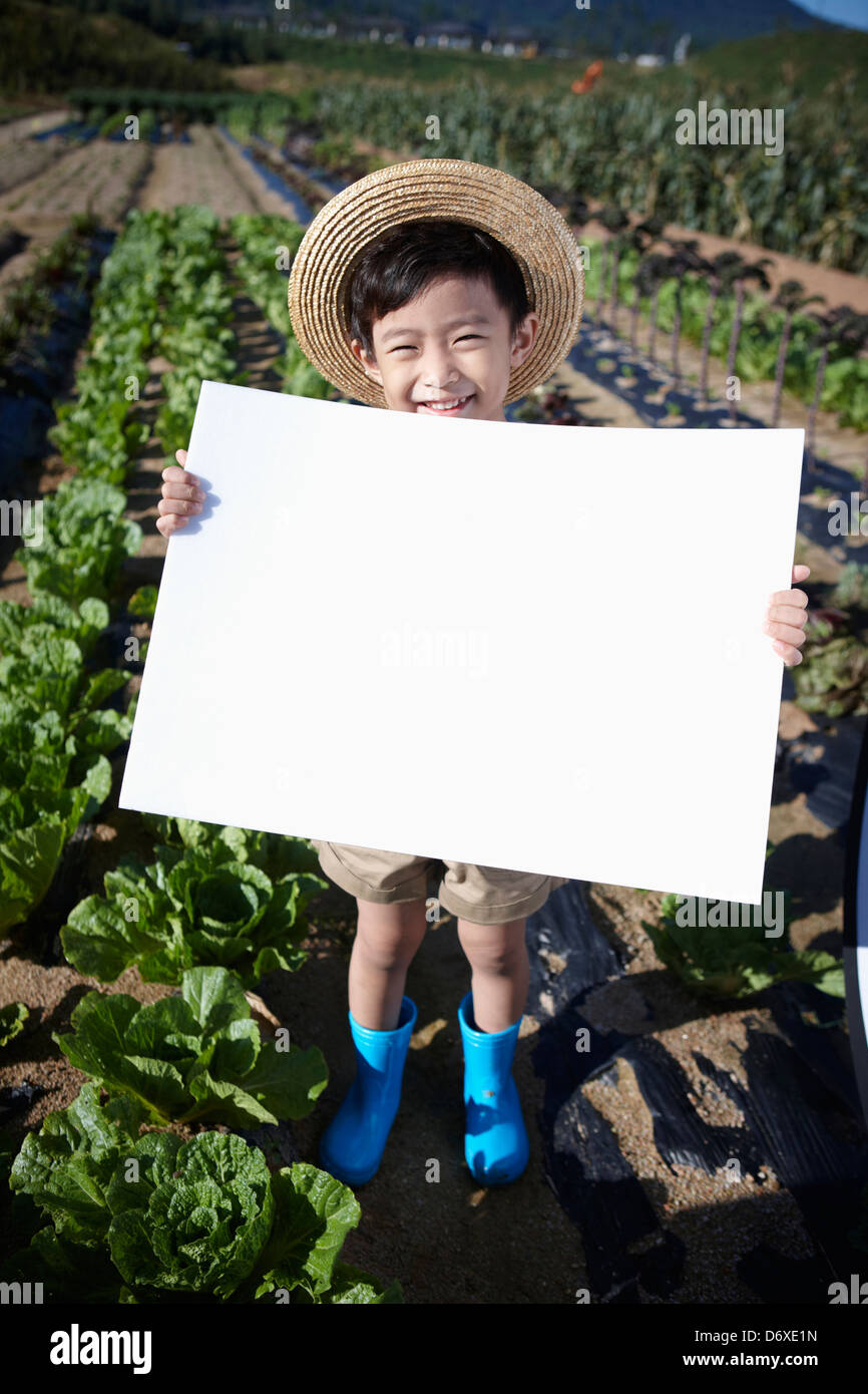 a boy holding an empty board in a farm Stock Photo - Alamy