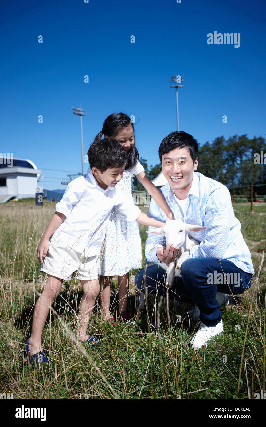 father and kids with a goat in a farm Stock Photo - Alamy