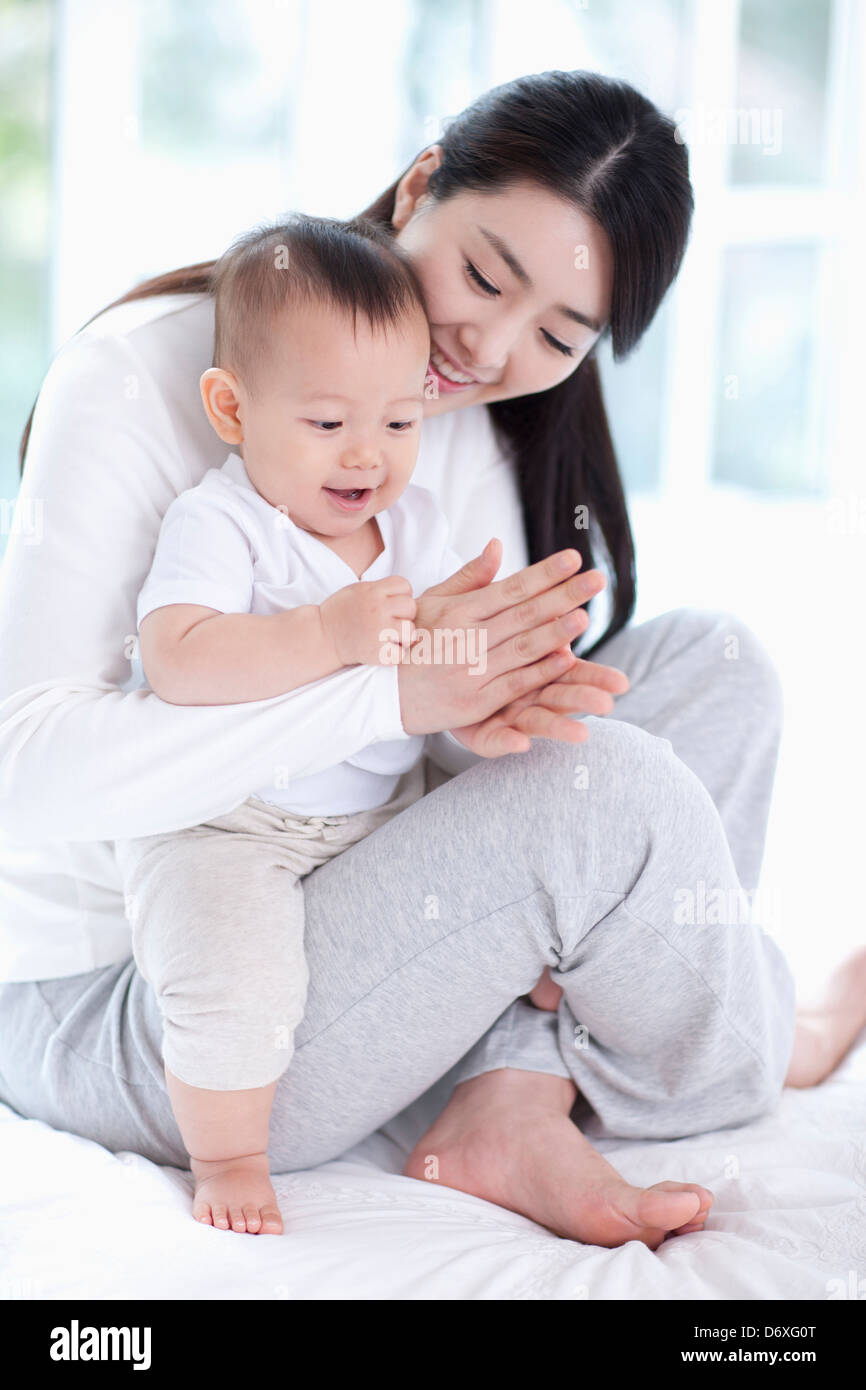 baby sitting on mother's lap Stock Photo - Alamy