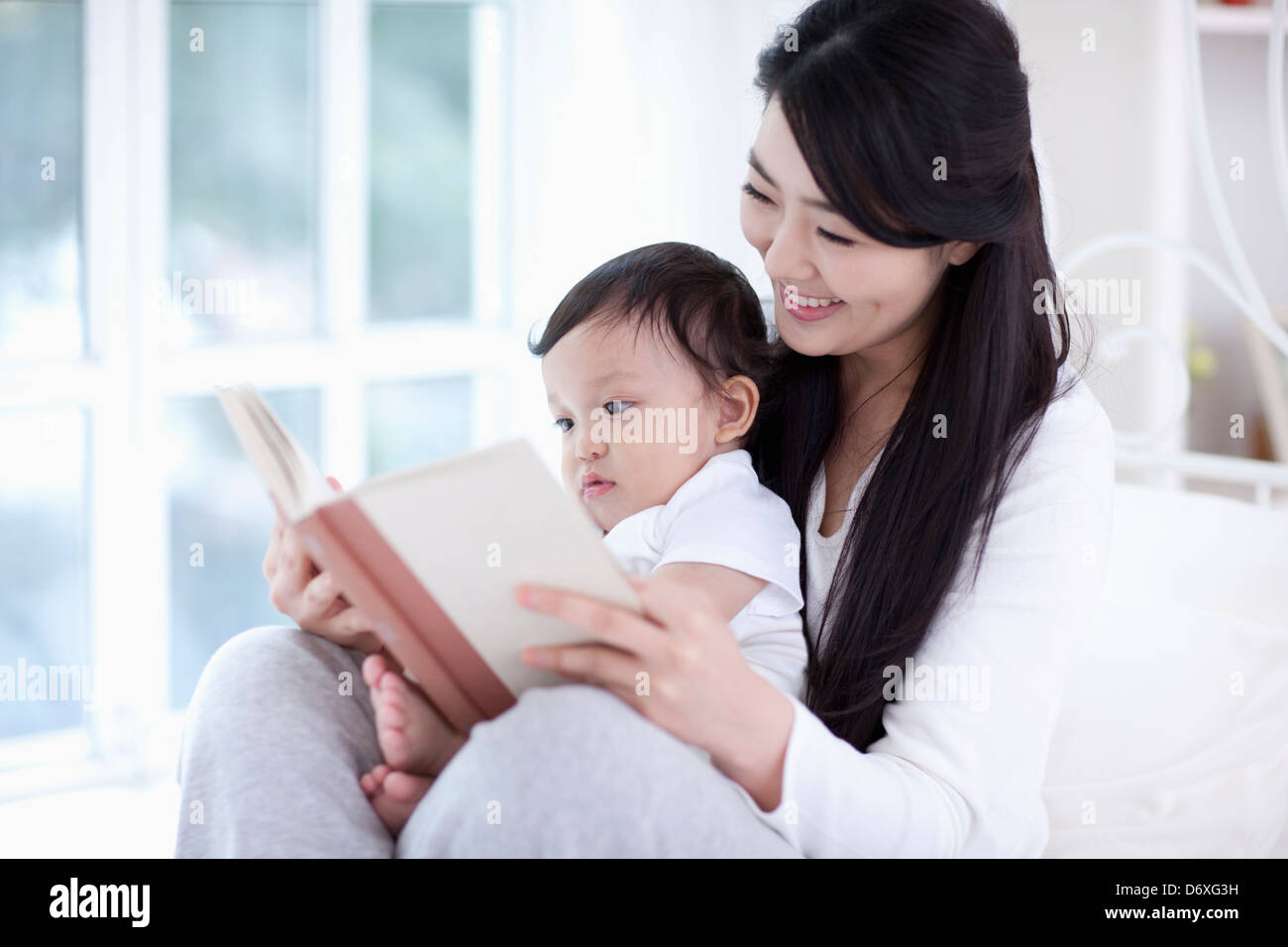 mother and baby reading a book together Stock Photo - Alamy