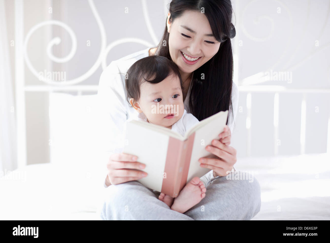 mother and baby reading a book together Stock Photo - Alamy