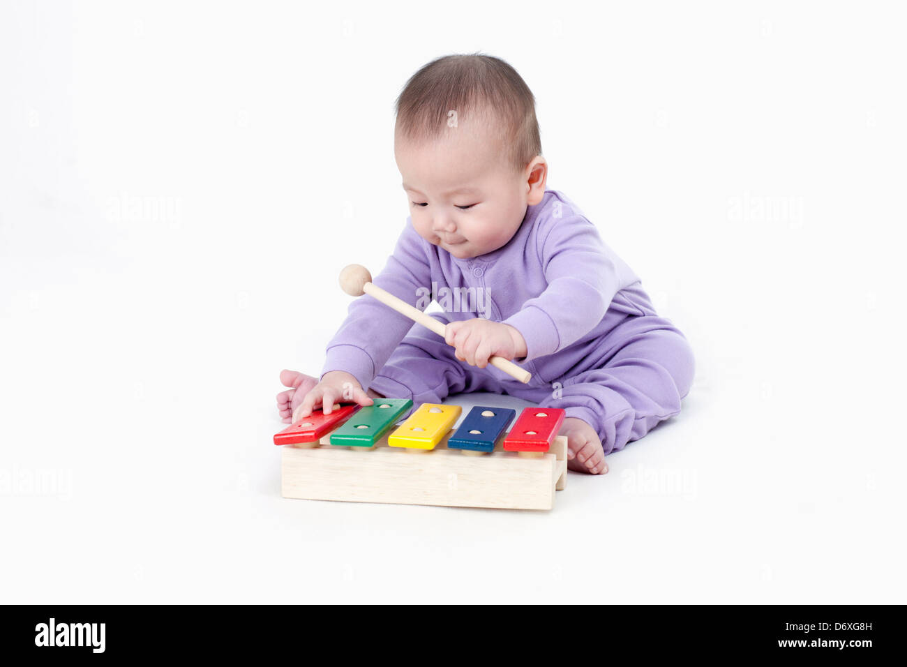 baby in purple clothes playing with xylophone Stock Photo - Alamy