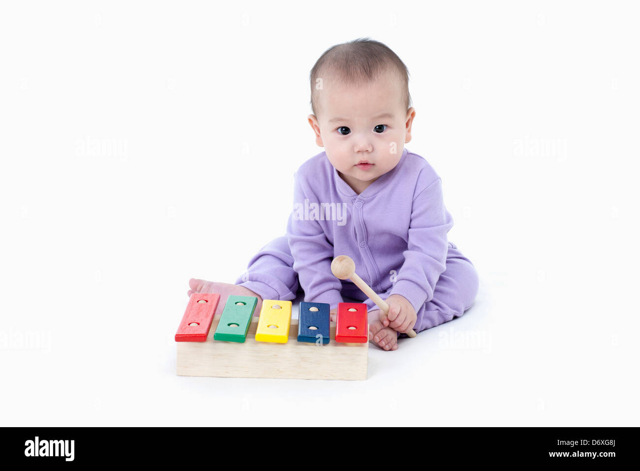 baby in purple clothes playing with xylophone Stock Photo - Alamy
