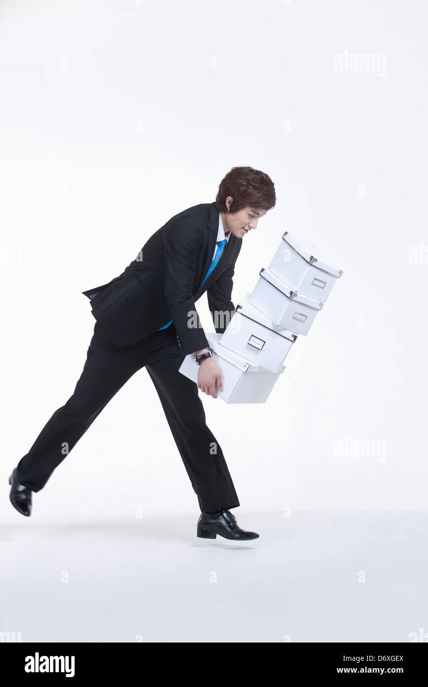 a man in business suit holding a pile of boxes Stock Photo - Alamy