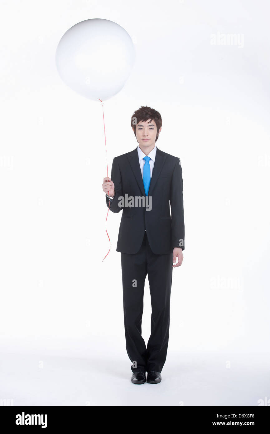 a man in business suit holding a big white balloon Stock Photo - Alamy