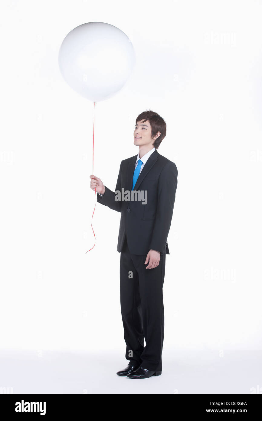 a man in business suit holding a big white balloon Stock Photo - Alamy