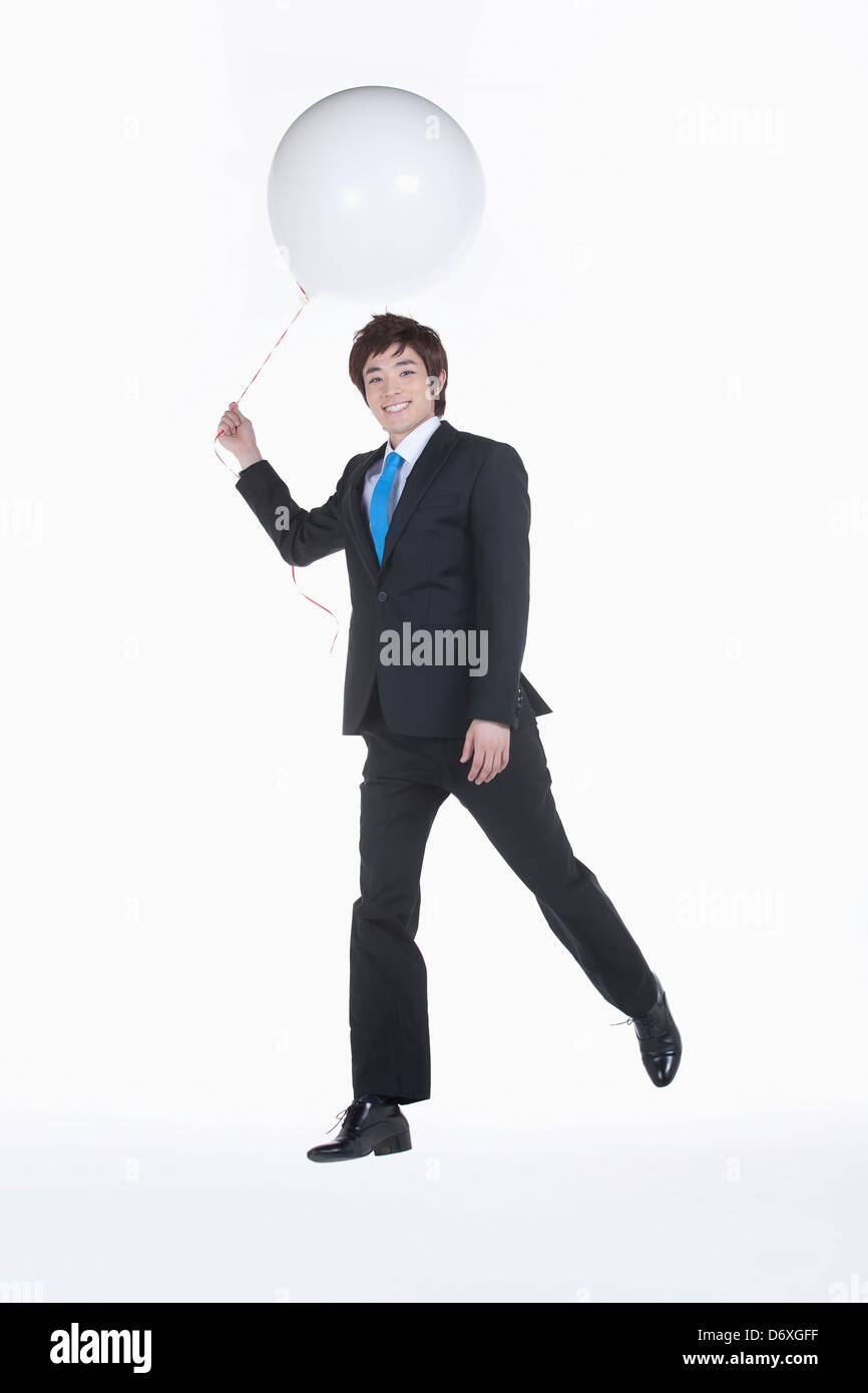 a man in business suit running with a big white balloon Stock Photo - Alamy