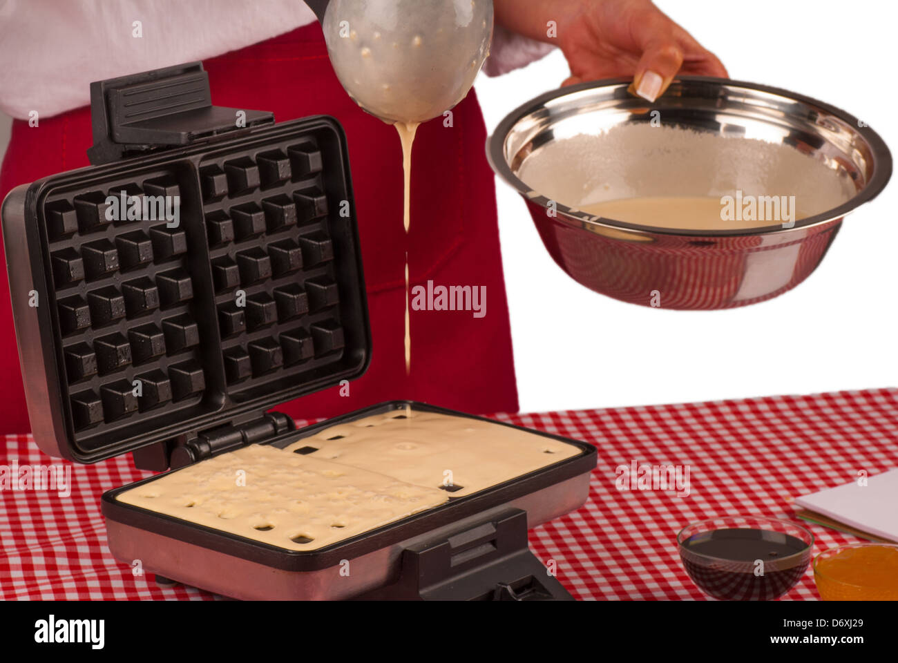 Fresh dough dripping on to a waffle iron Stock Photo - Alamy