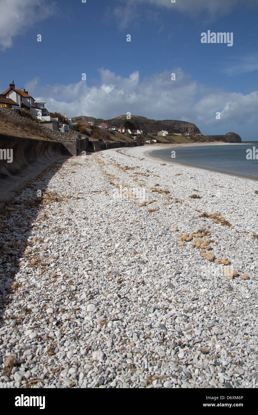 The Wales Coastal Path in North Wales. Pebble beach at Penrhyn Bay, with the Little Orme in the ...