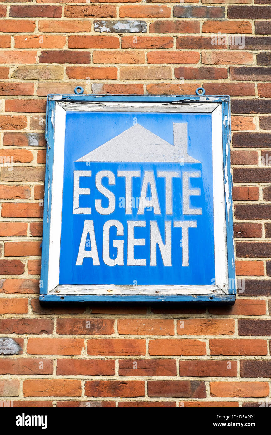 Looking up at old tatty blue and white Estate Agent sign Stock Photo ...