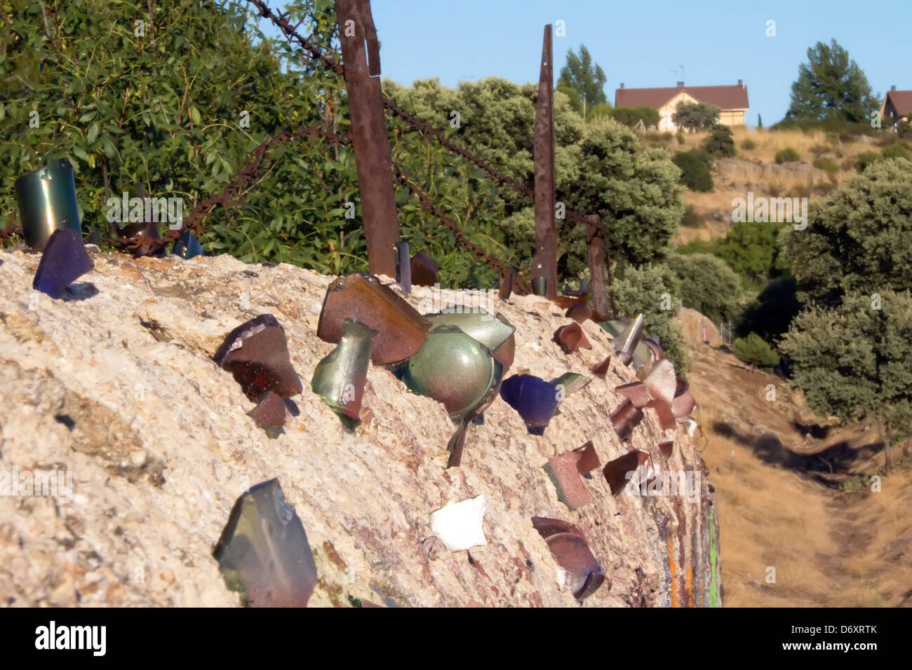 some broken glass embedded in a fence Stock Photo - Alamy