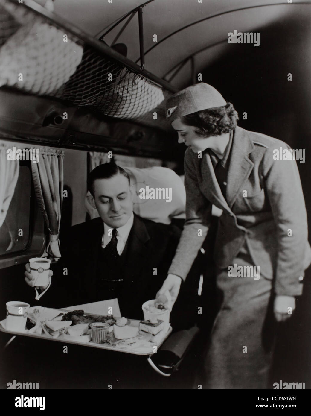 This image shows a stewardess at work, capturing a historical moment in ...