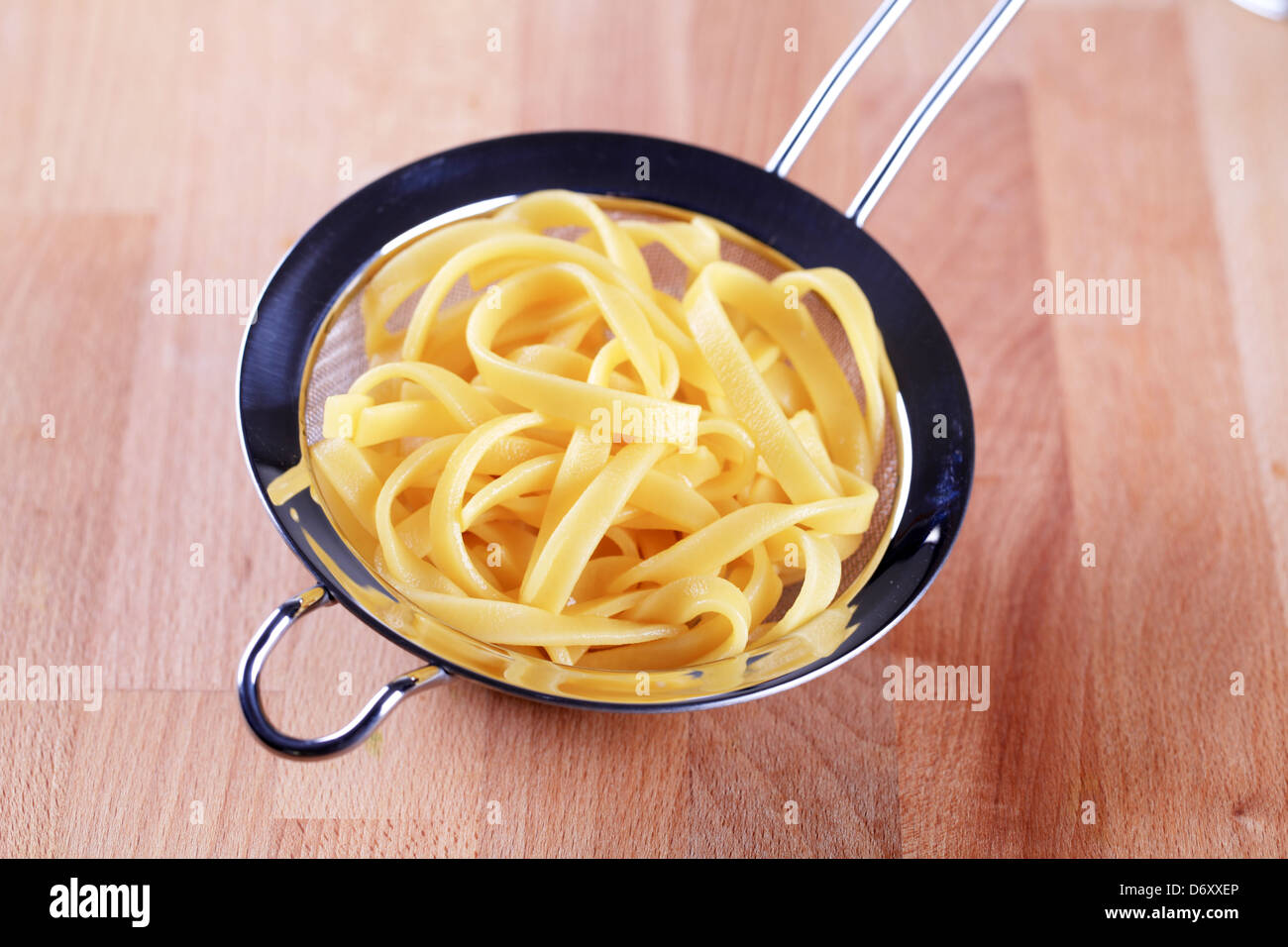 Cooked ribbon pasta in a metal sieve Stock Photo - Alamy