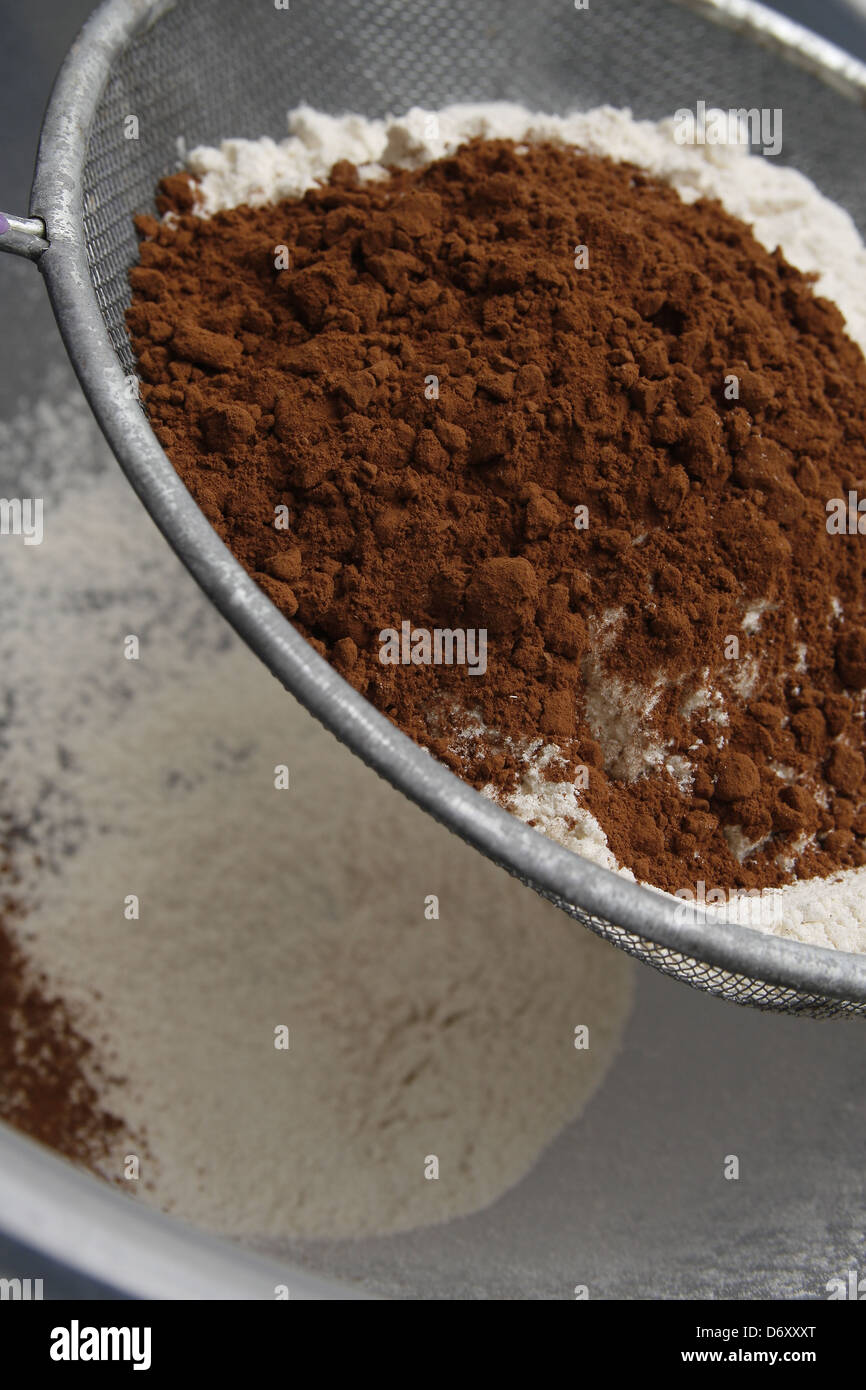 cocoa powder and plain flour in sieve over plastic mixing bowl Stock ...