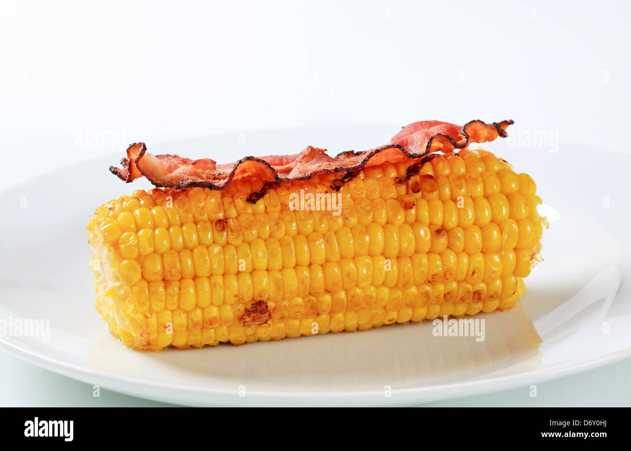 Corn on the cob and rasher of bacon Stock Photo - Alamy