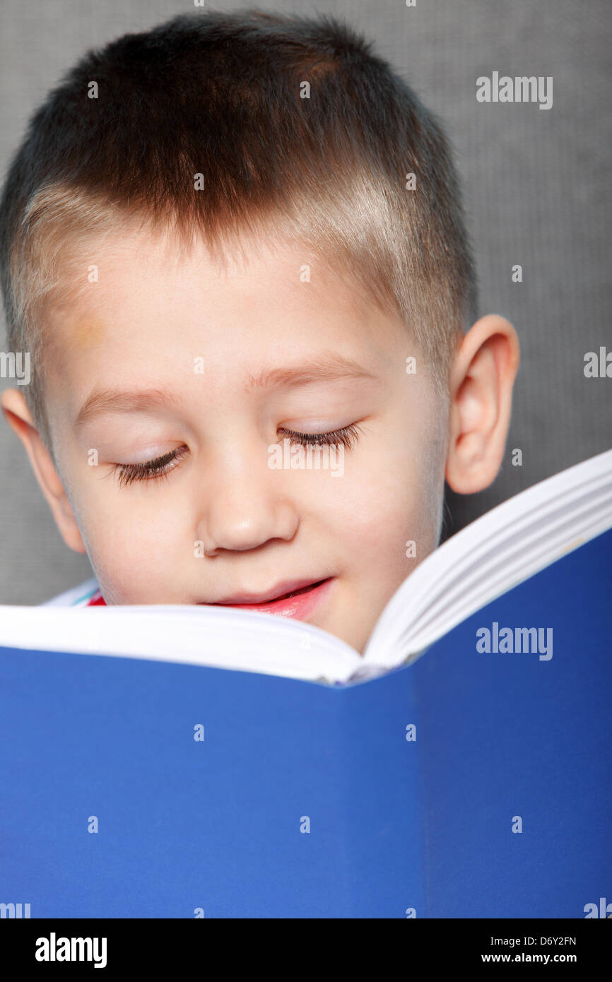 boy with a book, child on gray background holding an open book Stock ...