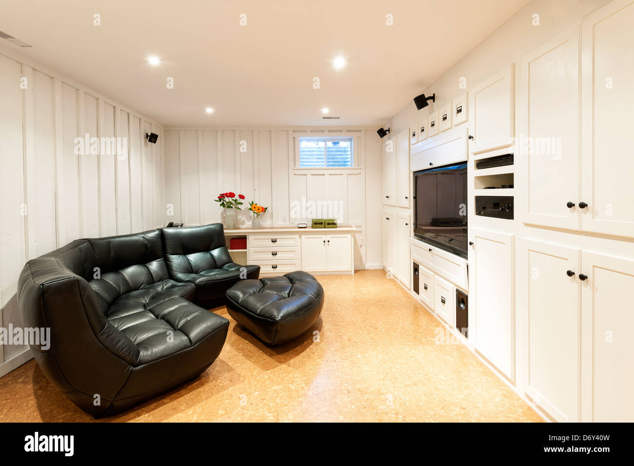 Finished basement of residential home with entertainment center, couch ...