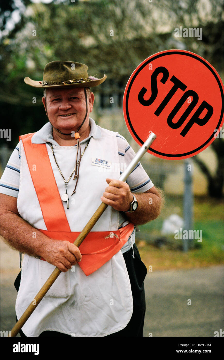 Rugged male crossing guard holding a stop sign, Australia Stock Photo ...