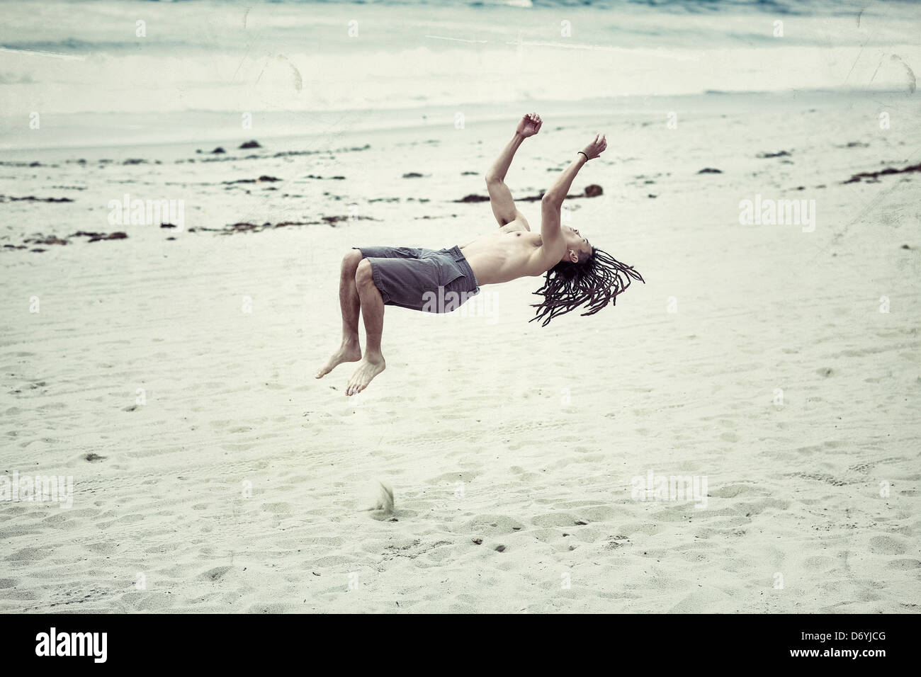 Chinese man doing back flip on beach Stock Photo - Alamy