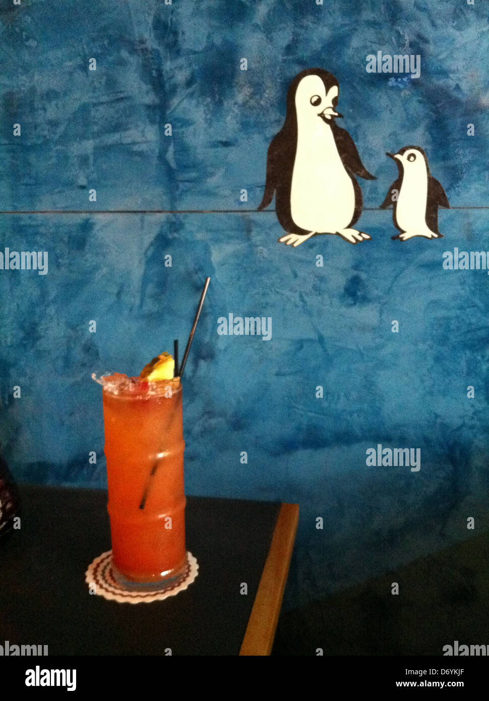 Tropical drink at table with penguin illustration Stock Photo - Alamy