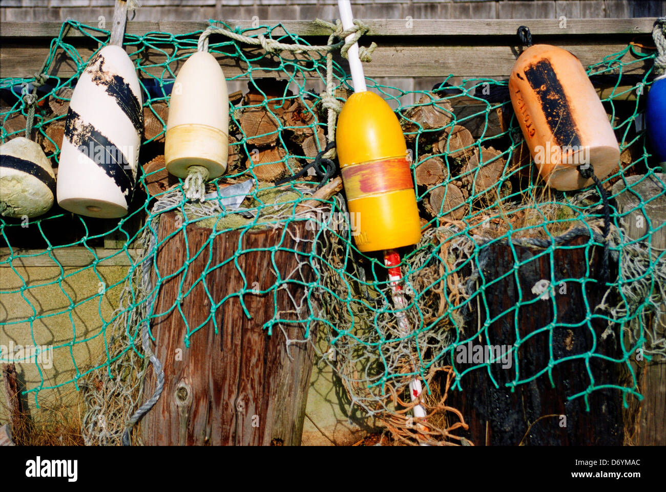 Buoys and a fishing net hanging to the edge of a dock at Menemsha ...