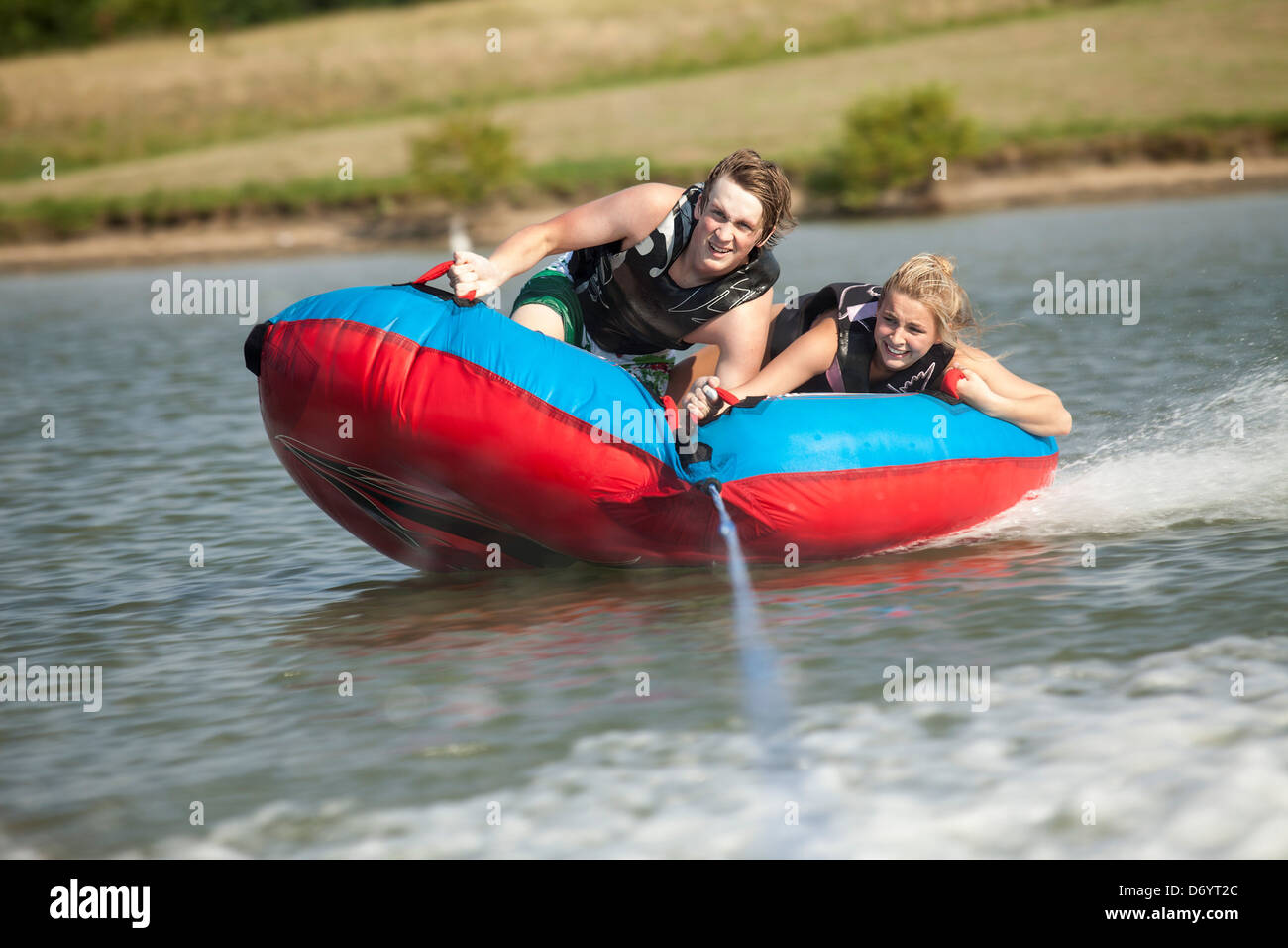 USA, Texas, Lewisville, Two teenagers riding on inner tube on Lake ...