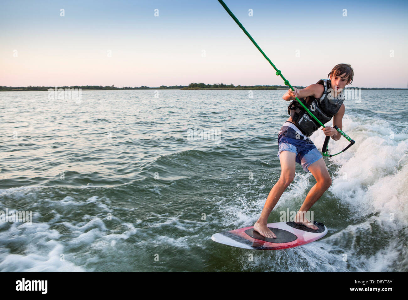 Teenage boy wakeboarding on lake Stock Photo - Alamy