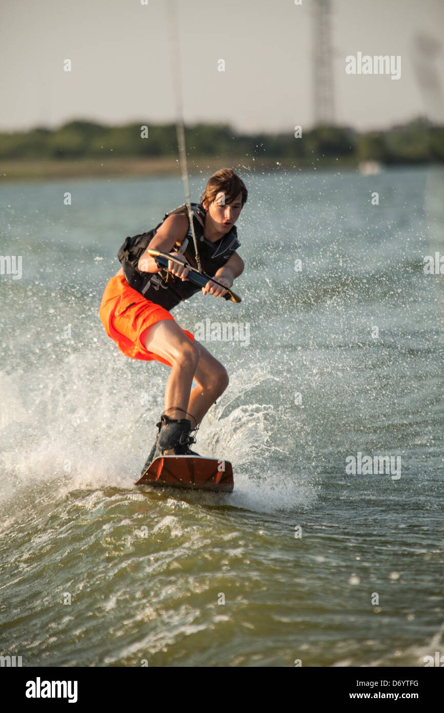 Teenage boy wakeboarding on lake Stock Photo - Alamy