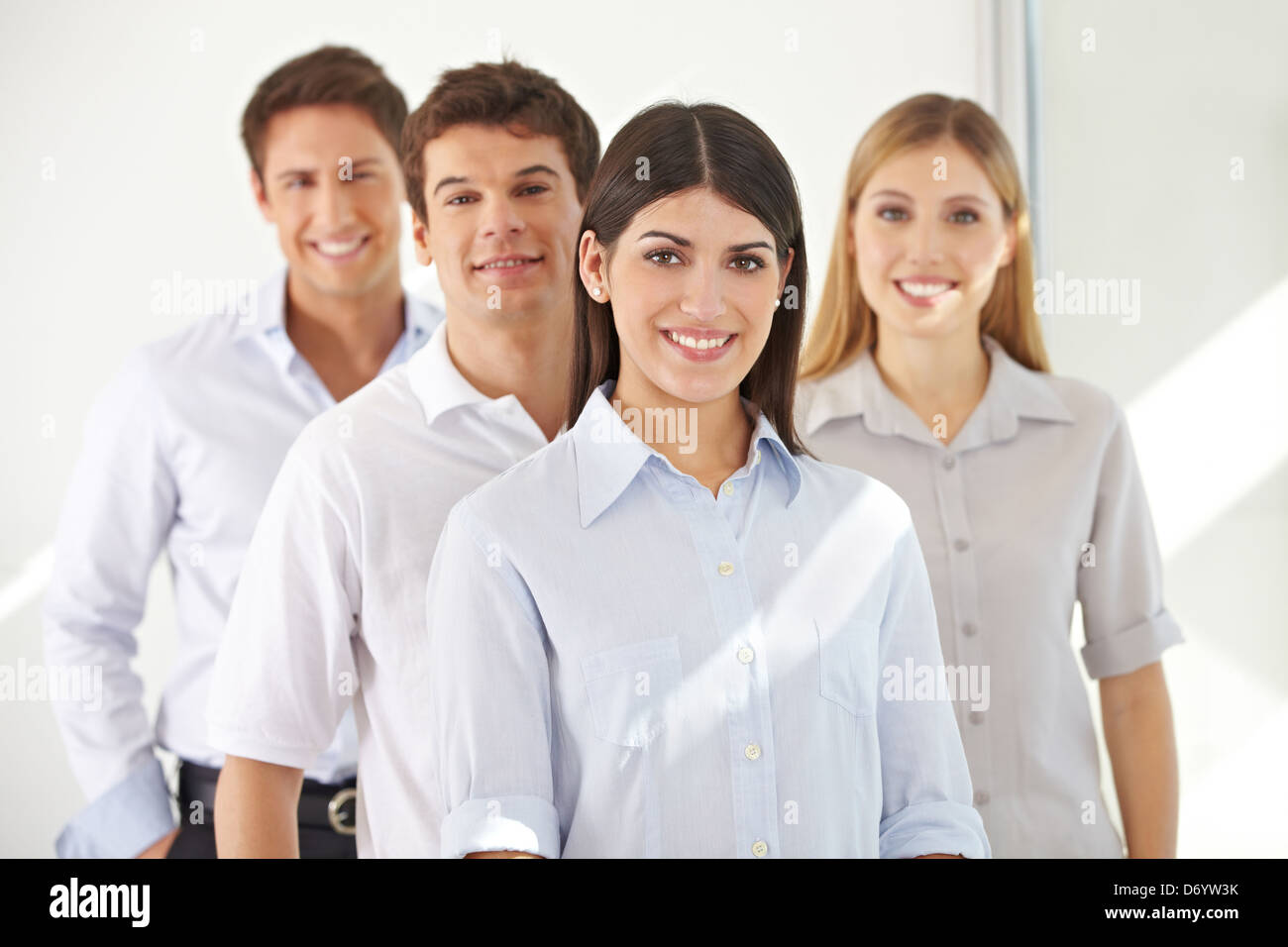 Smiling successful business team standing in a row Stock Photo - Alamy