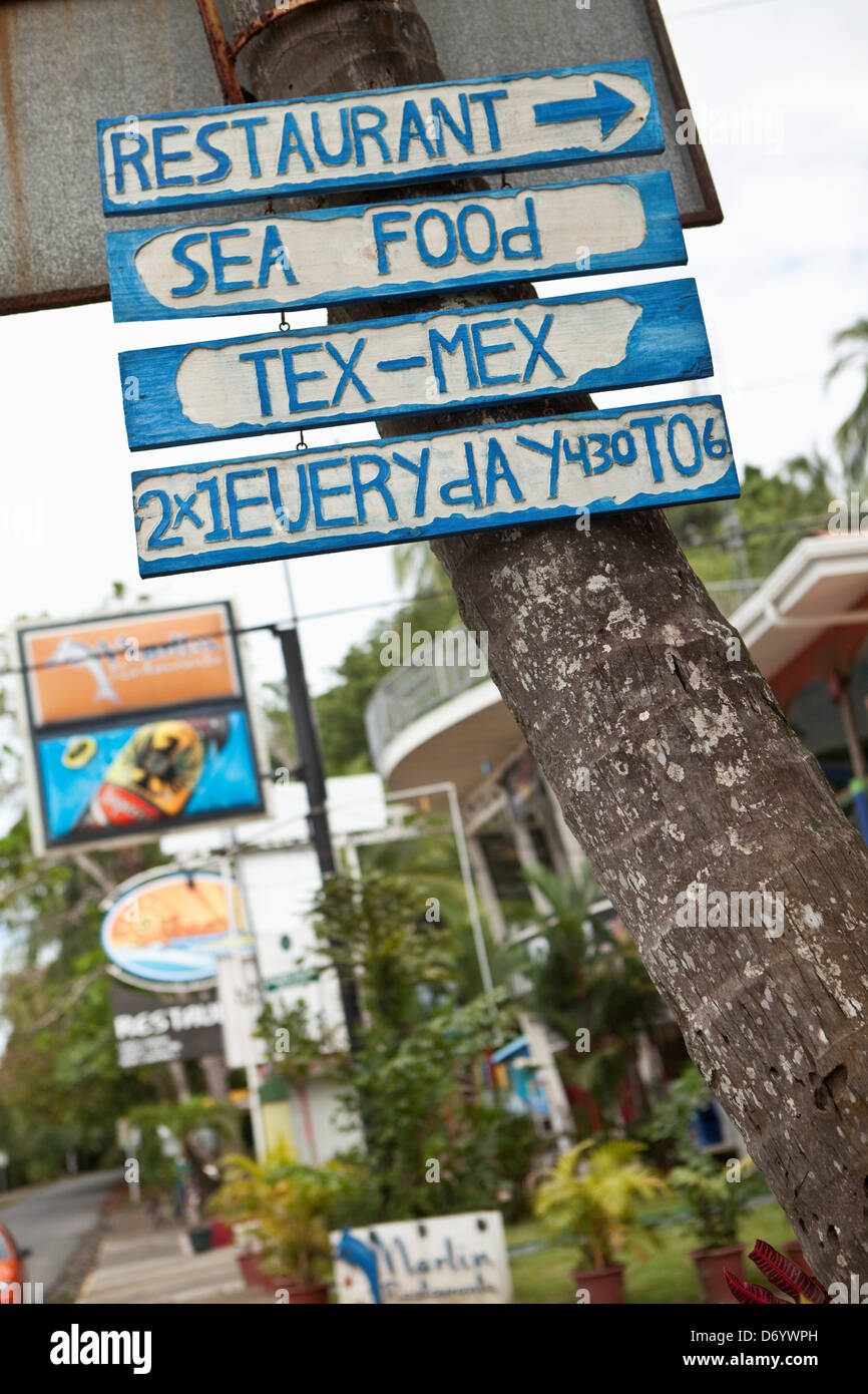 Directional signs nailed to a tree in Costa Rica Stock Photo - Alamy